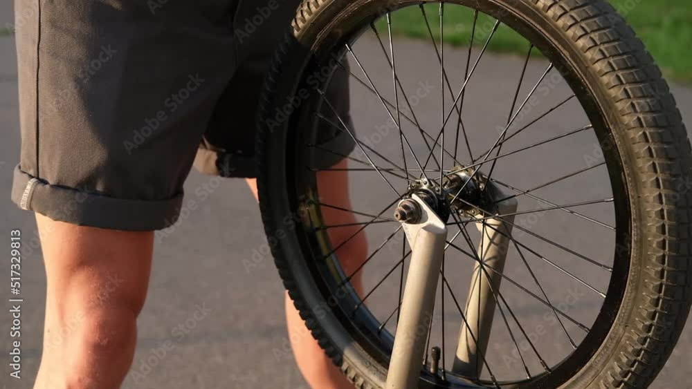 cyclist unscrewing and remove a bicycle wheel with a wrench while ...
