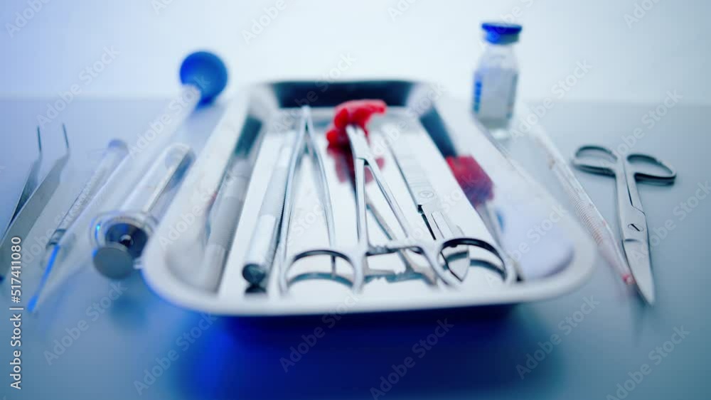 A surgeon is performing a surgery. Medical instruments in steel tray on ...