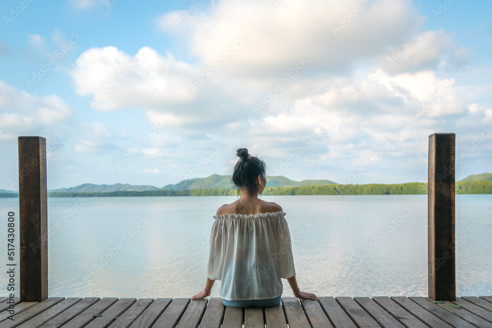 A tourist girl sit alone to see scenic view of mountain and lake at ...