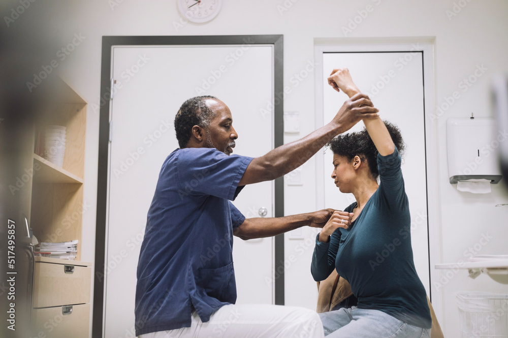 Side view of male doctor giving physical therapy to female patient ...