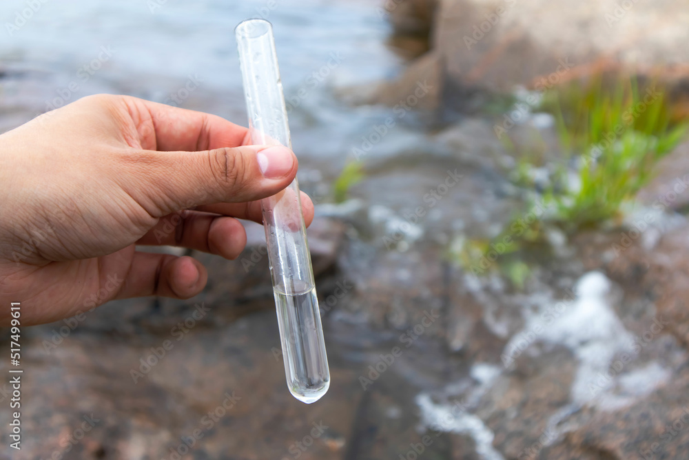 Water sample. Hand holding a test tube with water in nature. Water ...