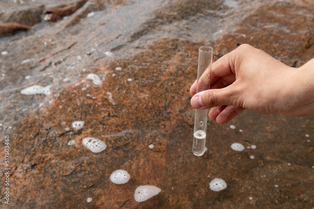 Water sample. Hand holding a test tube with water in nature. Water ...