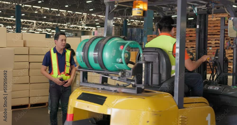 Using a forklift, transfer about a warehouse. a worker using a forklift ...