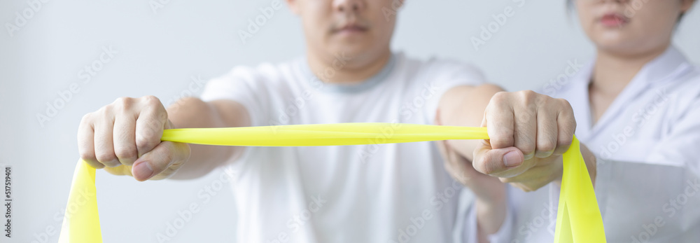 Physical therapy, Female physiotherapist uses an elastic band to test ...