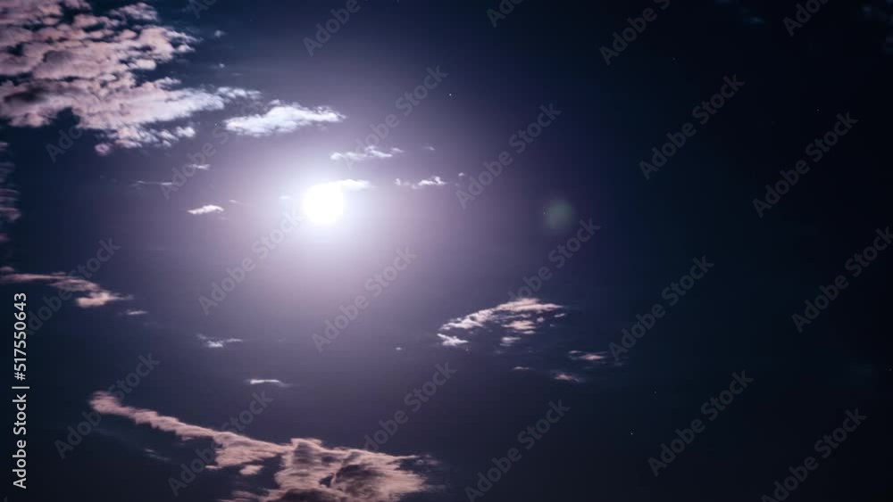 Stockvideon Full moon moves in the night sky through dark clouds ...