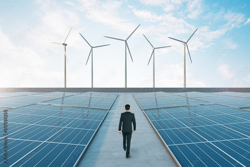 Green energy concept with wind mills and solar panels on bright sky ...