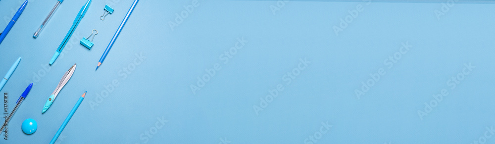 Pens pencils compasses paper clips laid out in lines all blue and ...