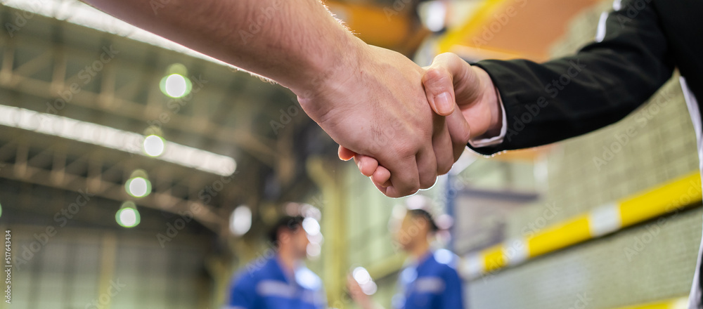 Asian businessman and woman handshake after negotiation in manufactory ...