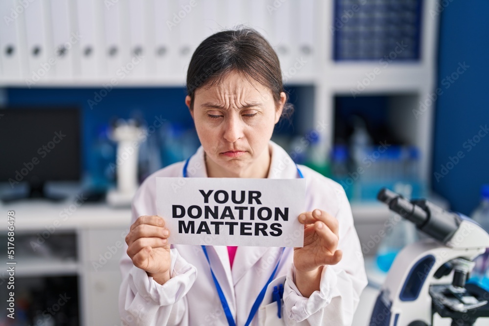 Woman with down syndrome working at scientist laboratory holding your ...
