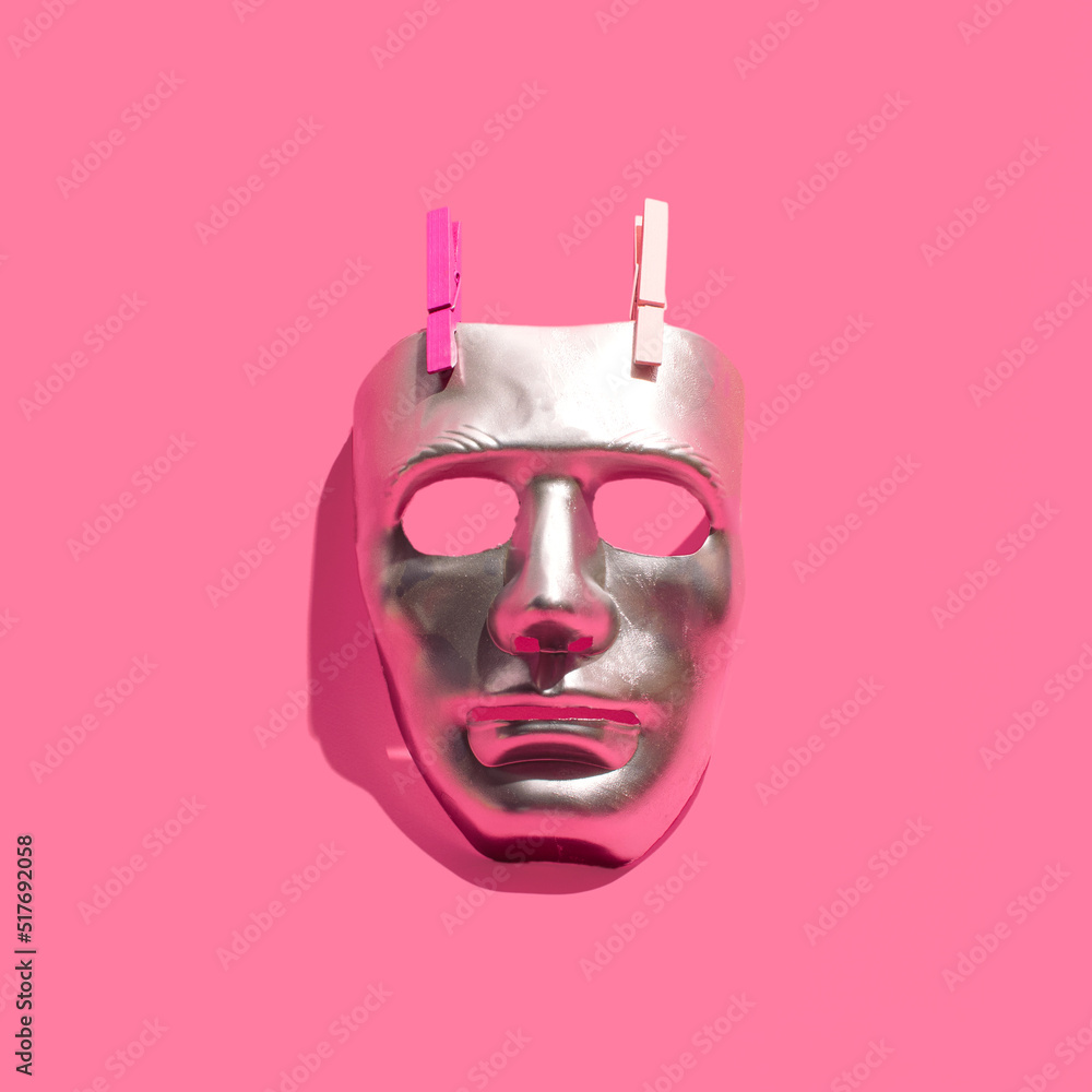 Metallic human mask and pink pegs, creative arrangement, summer ...