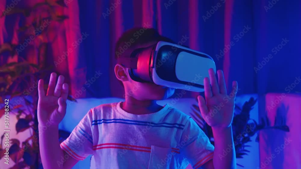 Asian little kid boy wearing virtual reality goggles experiencing ...