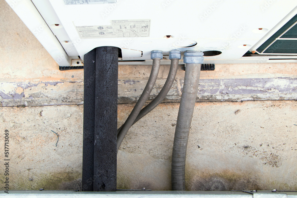 Old black plastic refrigerant pipe air connected to the back of a large ...