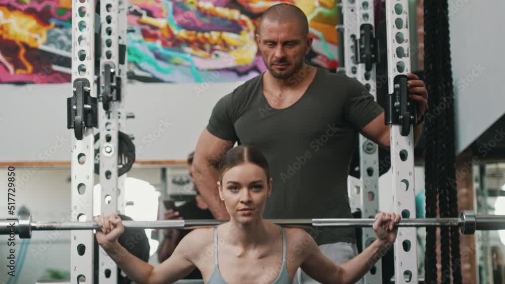Barbell lifting. Young beautiful caucasian brunette trying out ...