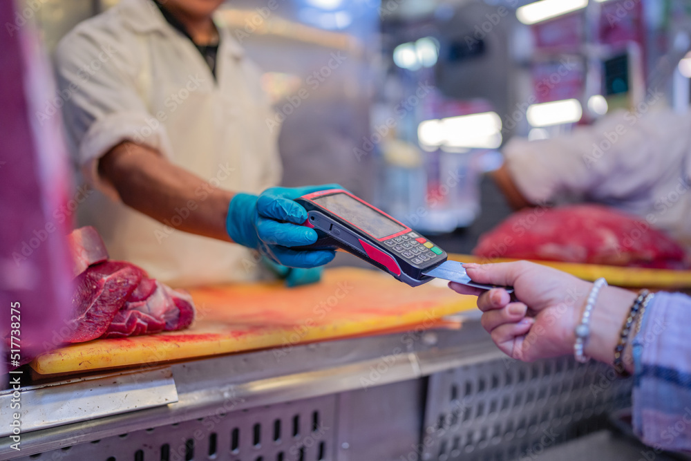 Crop butcher receiving payment from customer Stock Photo | Adobe Stock