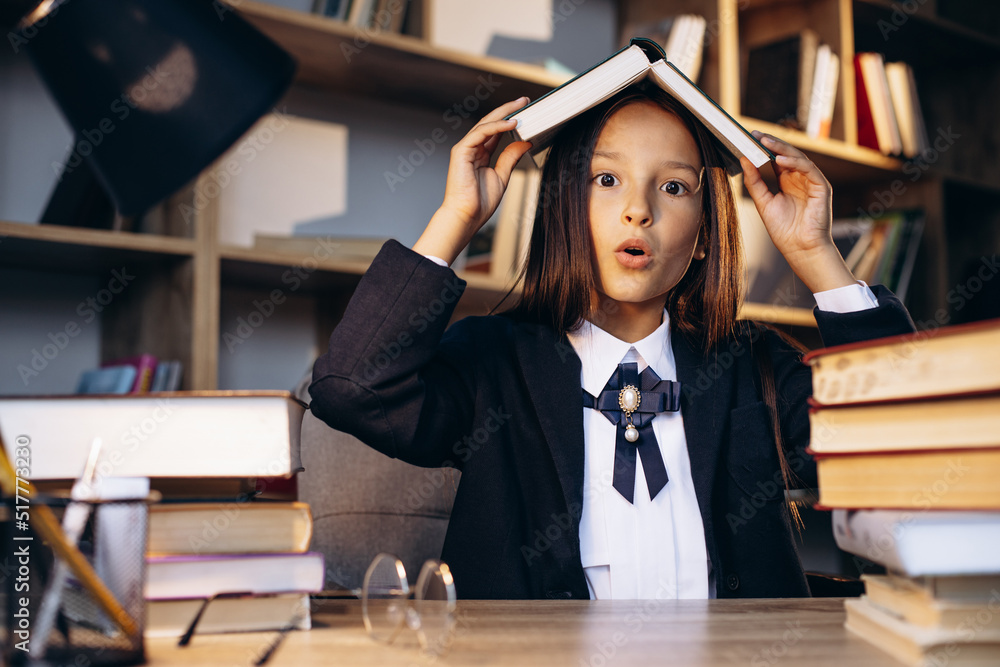 Pretty school girl reading books at the library Stock Photo | Adobe Stock