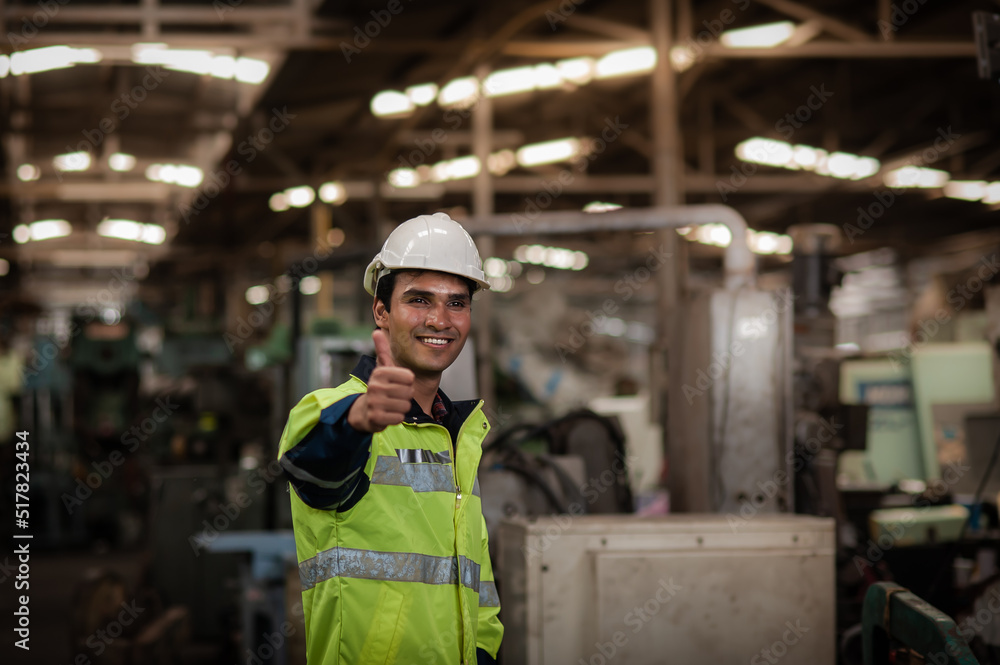 Happy Young Indian male engineer wearing safety workwear standing in ...
