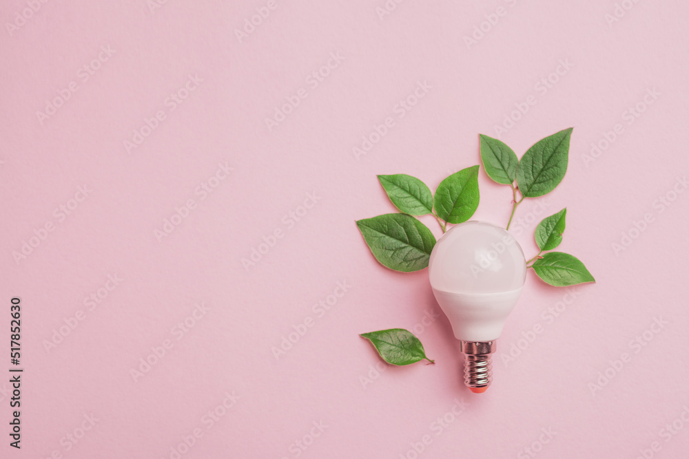 Energy saving lightbulb with green leaves background. Save energy, eco ...