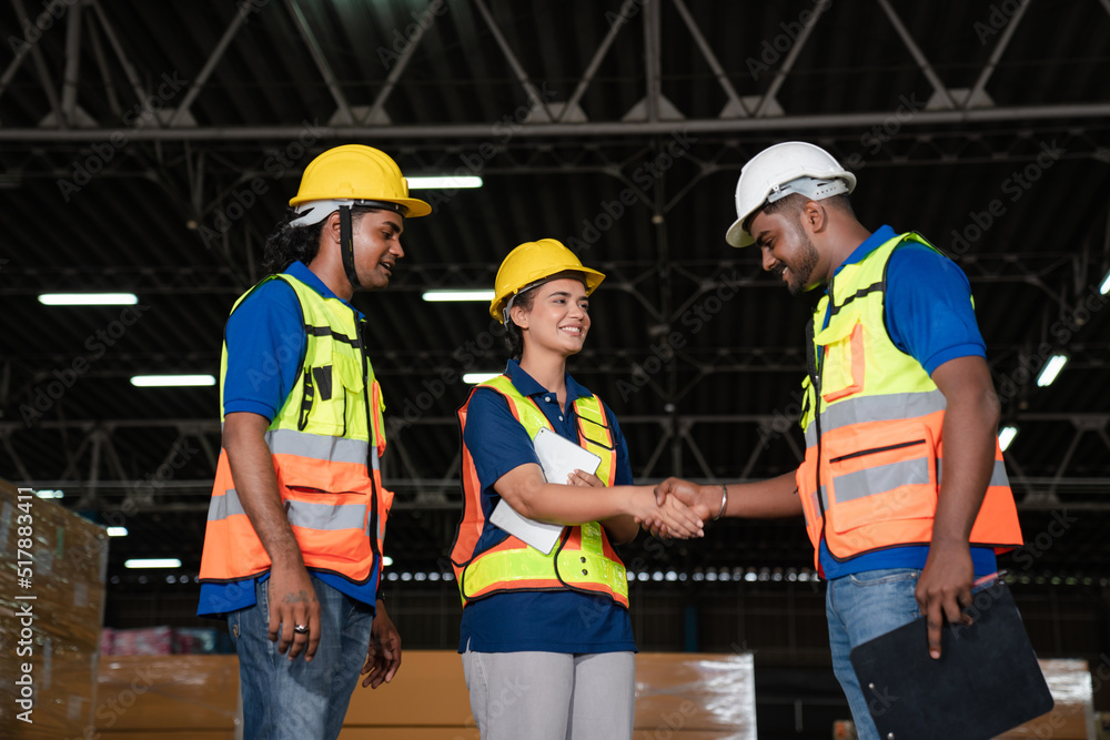Male staff workers shaking hands with deals in warehouse, success ...