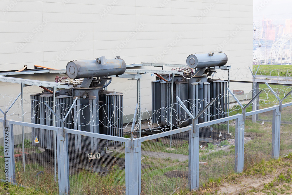 Two high voltage oil-filled power transformers on urban electrical ...