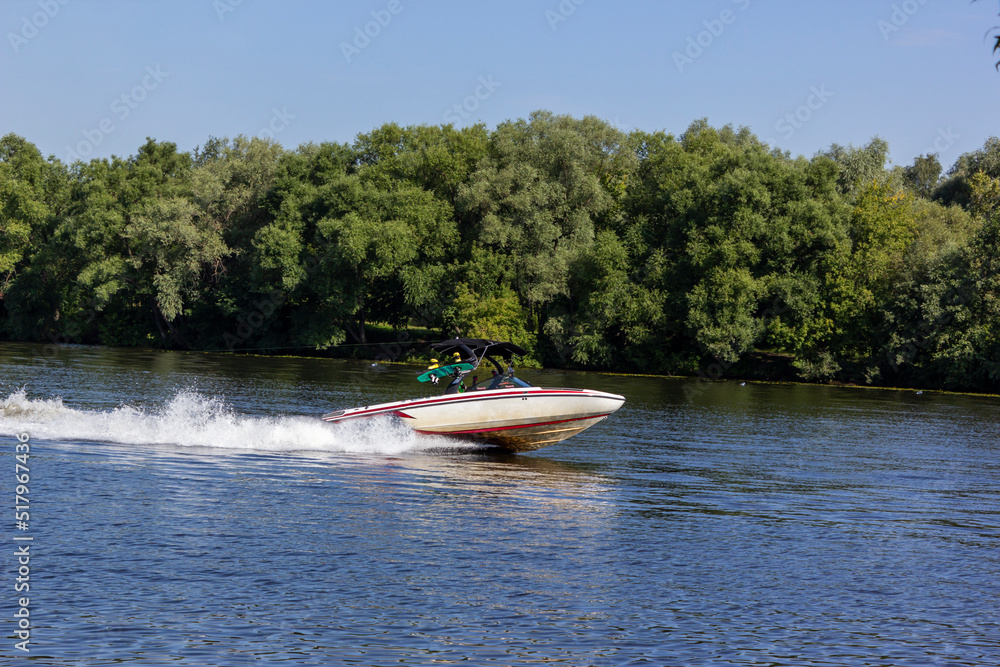Modern speedboat sailing on forest background. Summer leisure and water ...