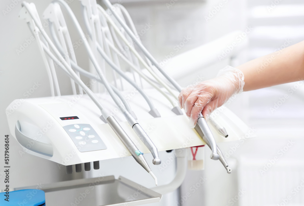 Dentist takes a tool in his hand. Various types of dental equipment in ...