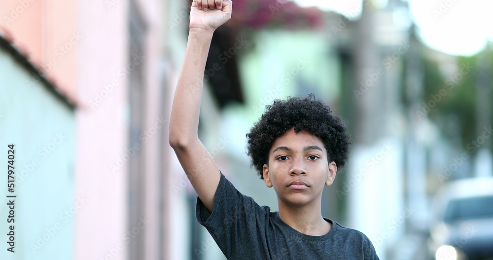 Little boy raises fist in air in protest. Mixed race child political ...