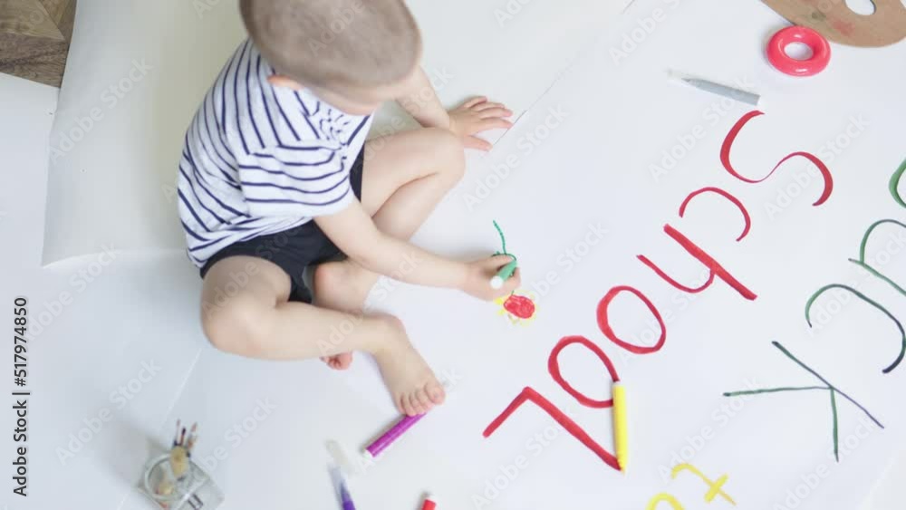 top view baby child kid boy coloring drawing sitting on floor, back to ...