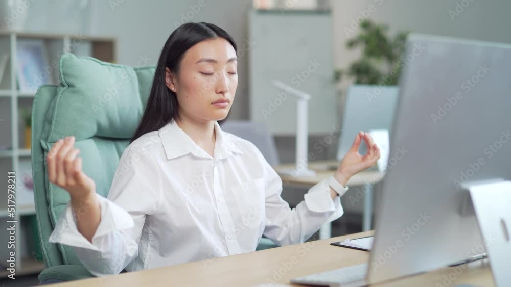 Asian young woman worker meditating at workplace in office. Female ...
