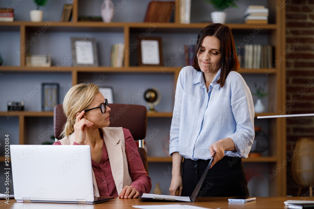Angry female boss scolding sad and scared office worker. Demanding ...