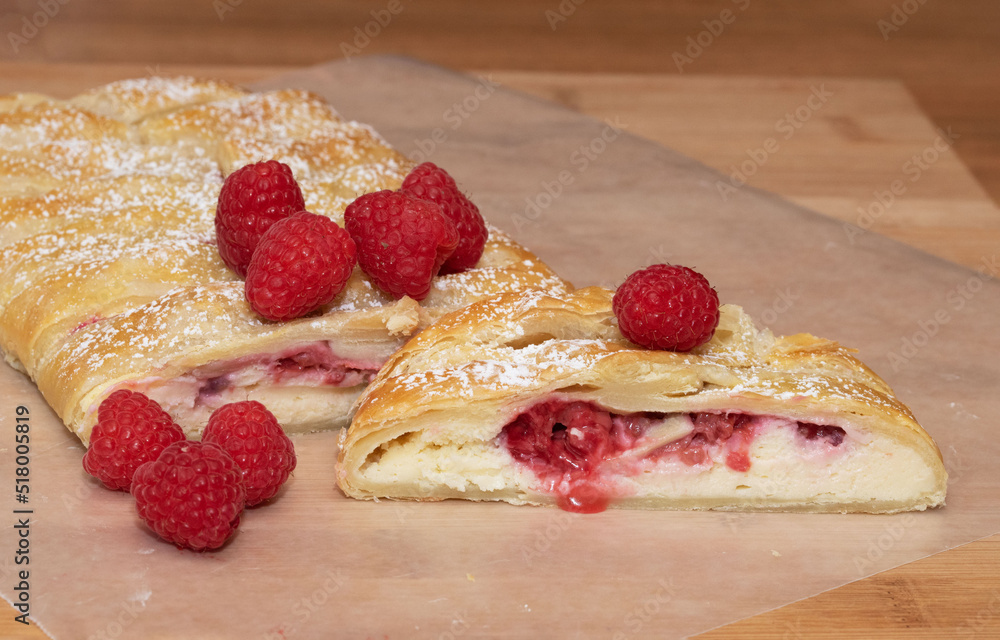 Raspberry cheesecake in braided puff pastry is homebred and sliced to ...
