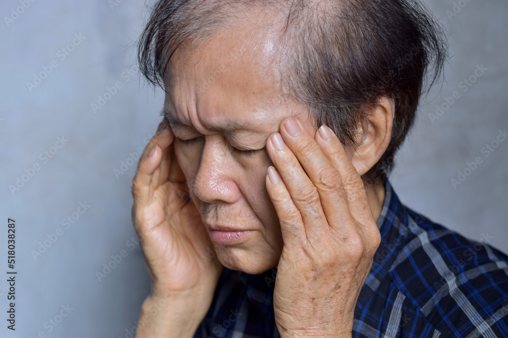 Asian man massaging his temple. Concept of eye pain, strain or cluster ...