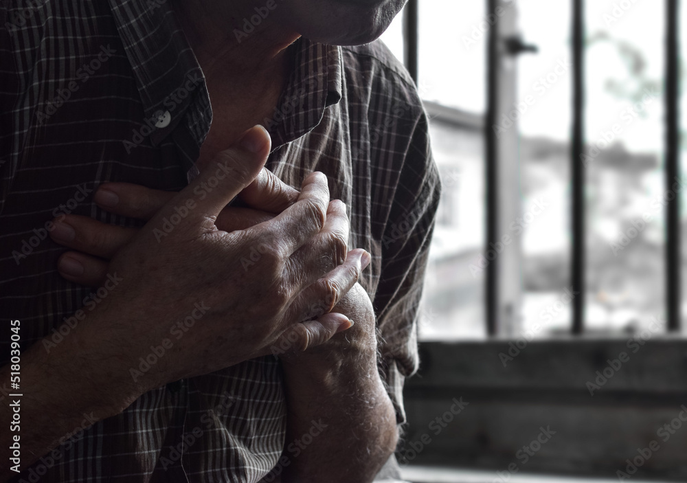 Partial silhouette image of Asian man suffering from central chest pain ...