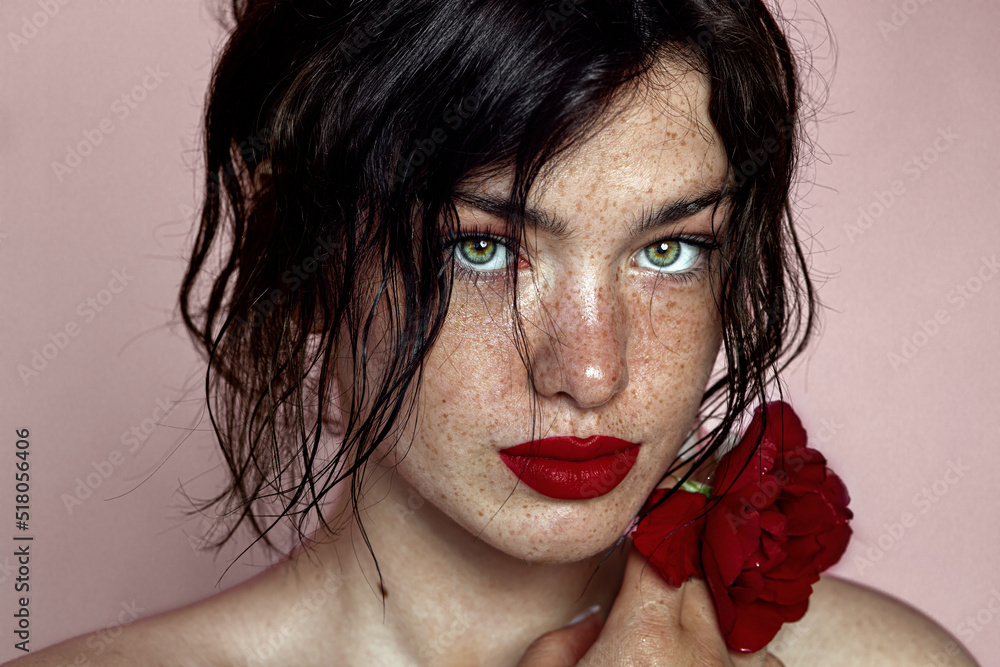 beauty young woman face with a lot of freckles and red lips, red rose ...
