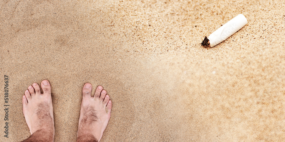 Men's feet stand against the background of sand, on which lies a ...