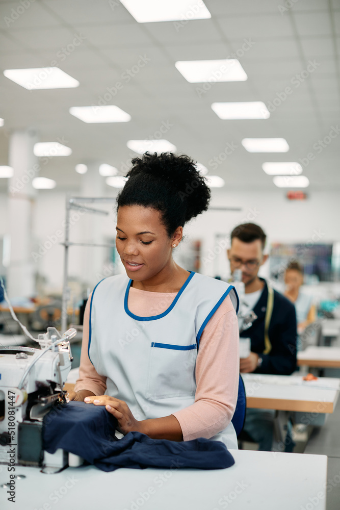 Young black woman working as dressmaker in textile factory. Stock Photo ...