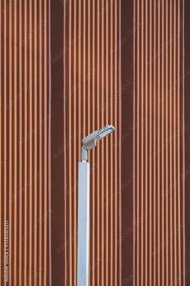 Modern LED solar power street light post against wooden trellis wall ...