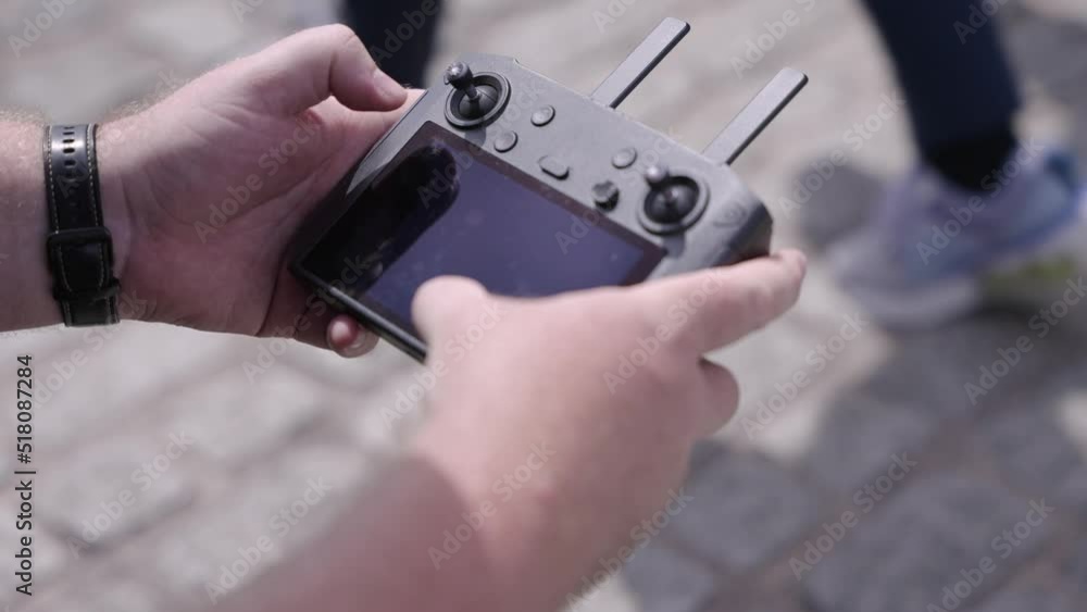 White male hands using DJI smart controller flying drone. Slow motion ...