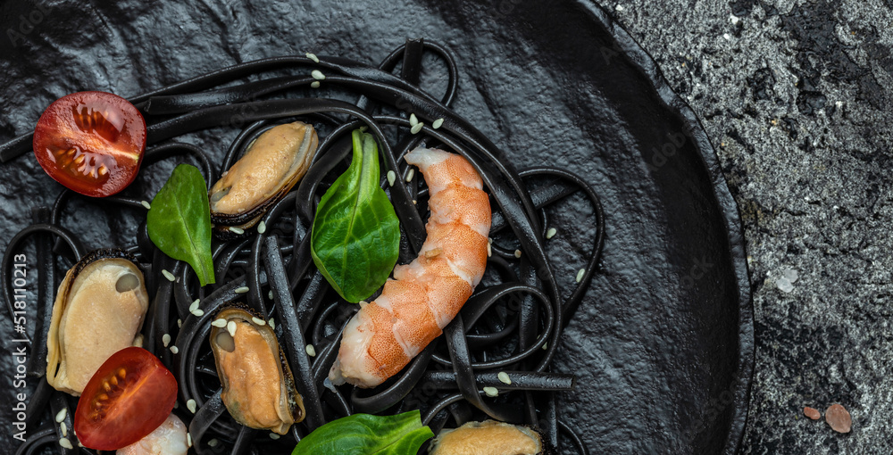 Squid ink spaghetti with seafood octopus, mussels and shrimps on dark ...