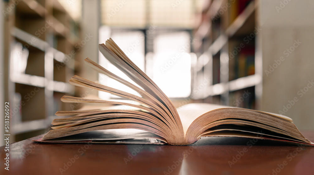 An open book or textbook in the library with light from the window on ...