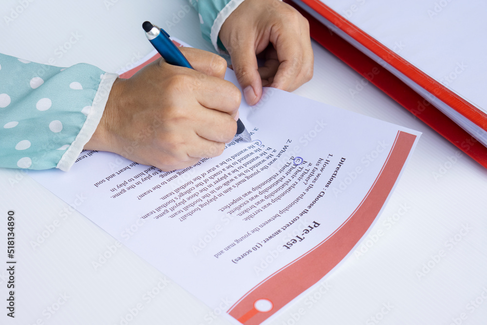 Closeup woman's hands is doing English examination on paper test ...