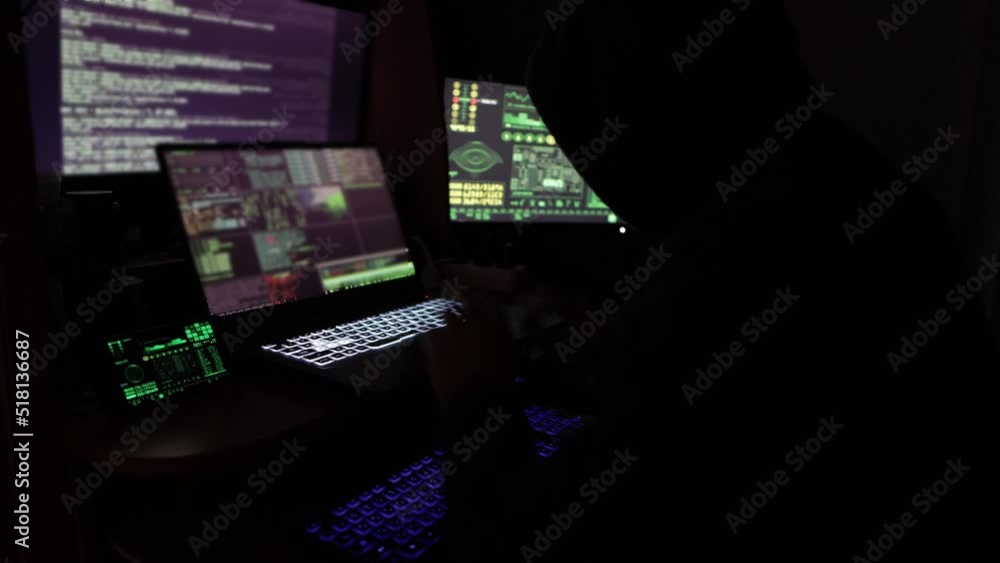 a hacker in a dark room in front of a monitor is trying to hack the ...