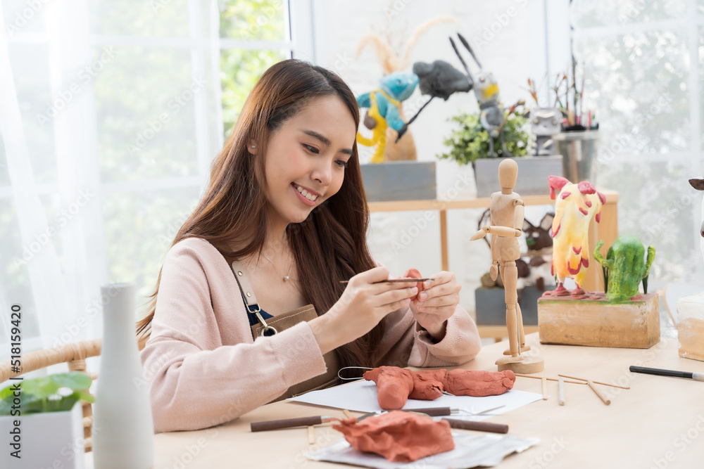 Young Asian girl making a sculpture with modeling clay at home .hobby ...