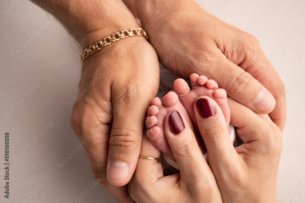 The palms of the parents. A father and mother hold the feet of a ...