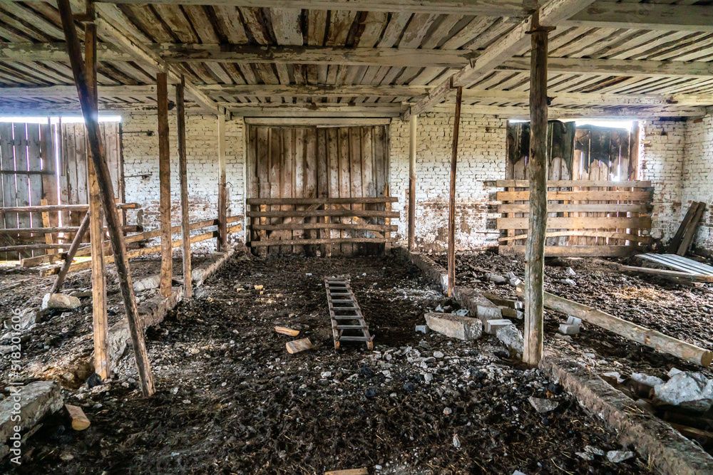 Abandoned ruined barn cowshed inside view. The old abandoned barn with ...