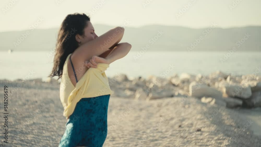 Slow motion video of a girl dropping her T-shirt and running to the sea ...