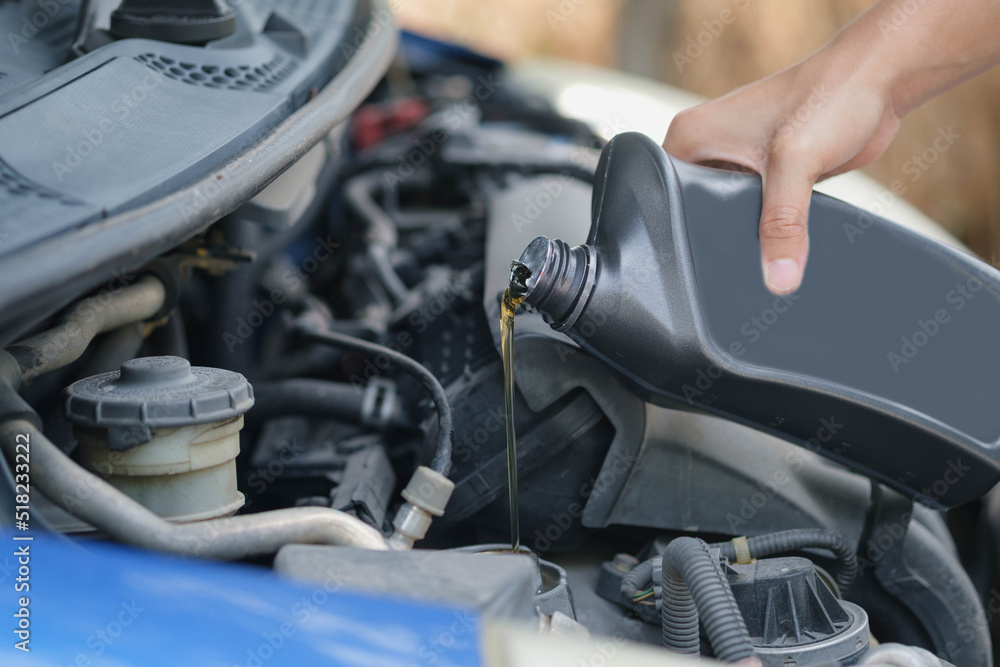 beautiful girl Refueling and pouring oil quality into the engine motor ...