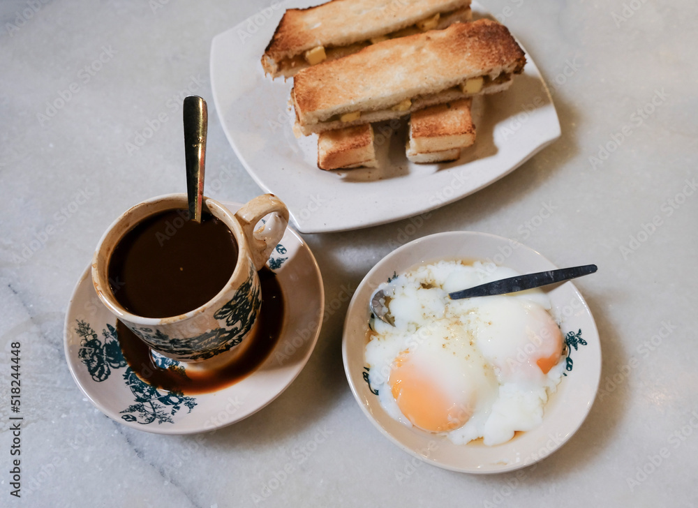 Breakfast in Malaysian Chinatown. Hainanese Breakfast. Toasted bread with butter and kaya, half ...