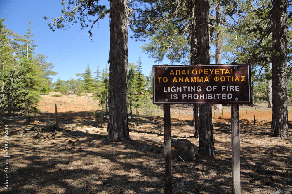 Sign with worning LIGHTNING OF FIRE IS PROHIBITED in Englisha and Greek ...