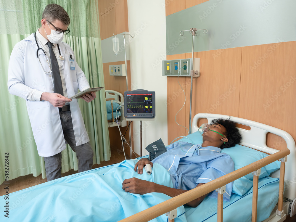 At hospital intensive care unit patient in coma lay on bed ...