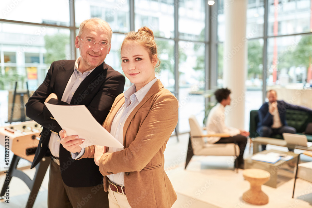 Erfolgreicher Berater und junge Kollegin als Trainee im Büro Stock ...